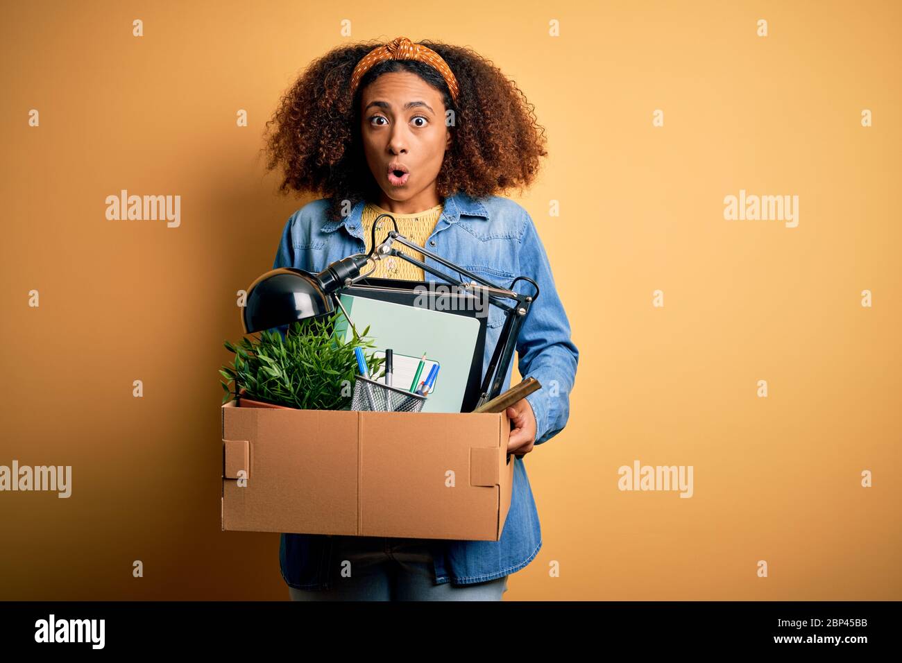 Young african american fired woman with afro hair holding cardboard box ...