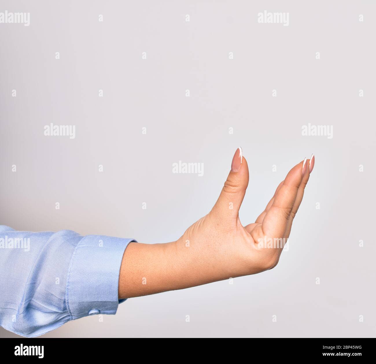 Hand of caucasian young woman doing catch sign over isolated white ...