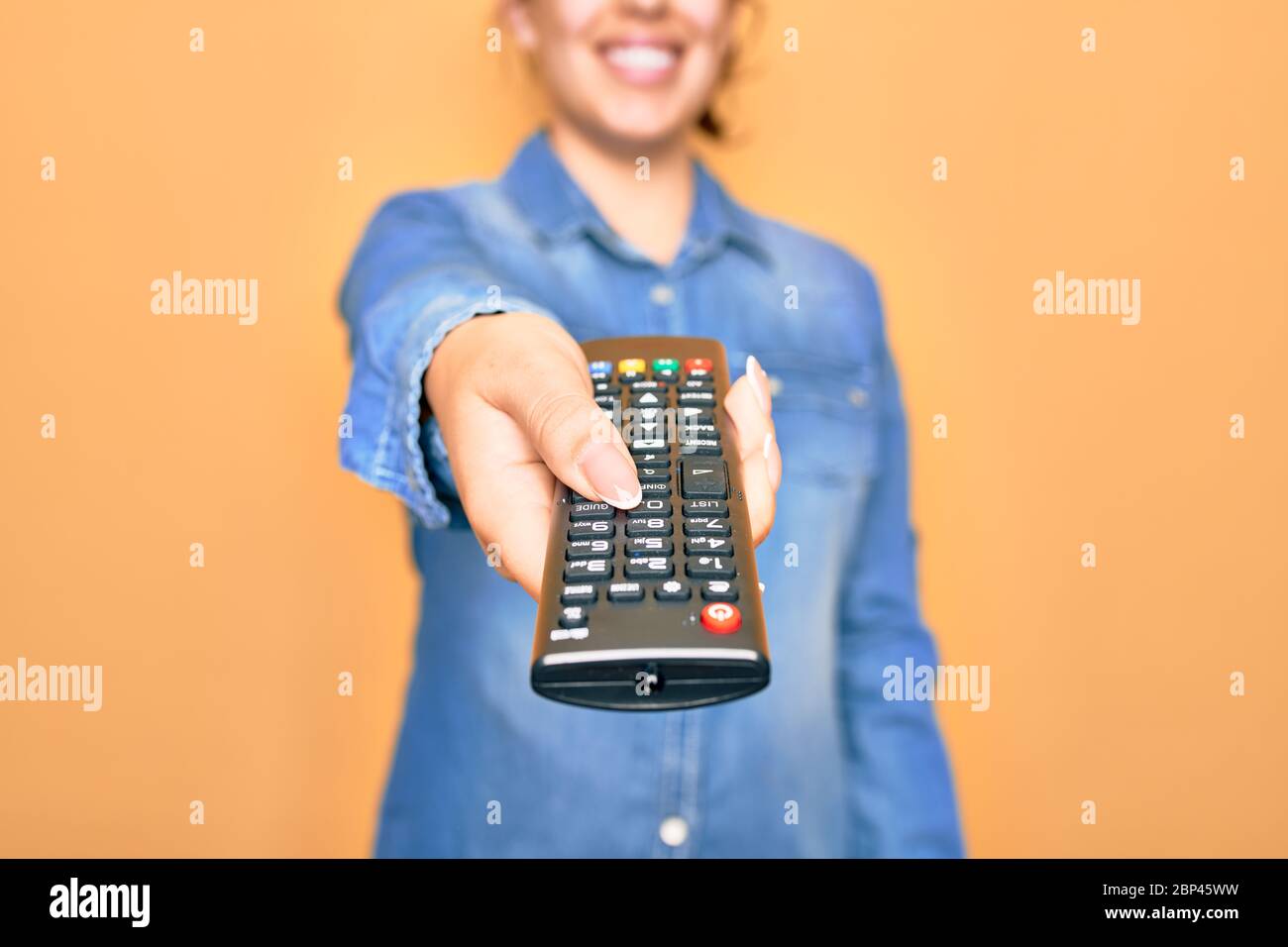 Woman changing television channel holding tv remote control. Standing ...
