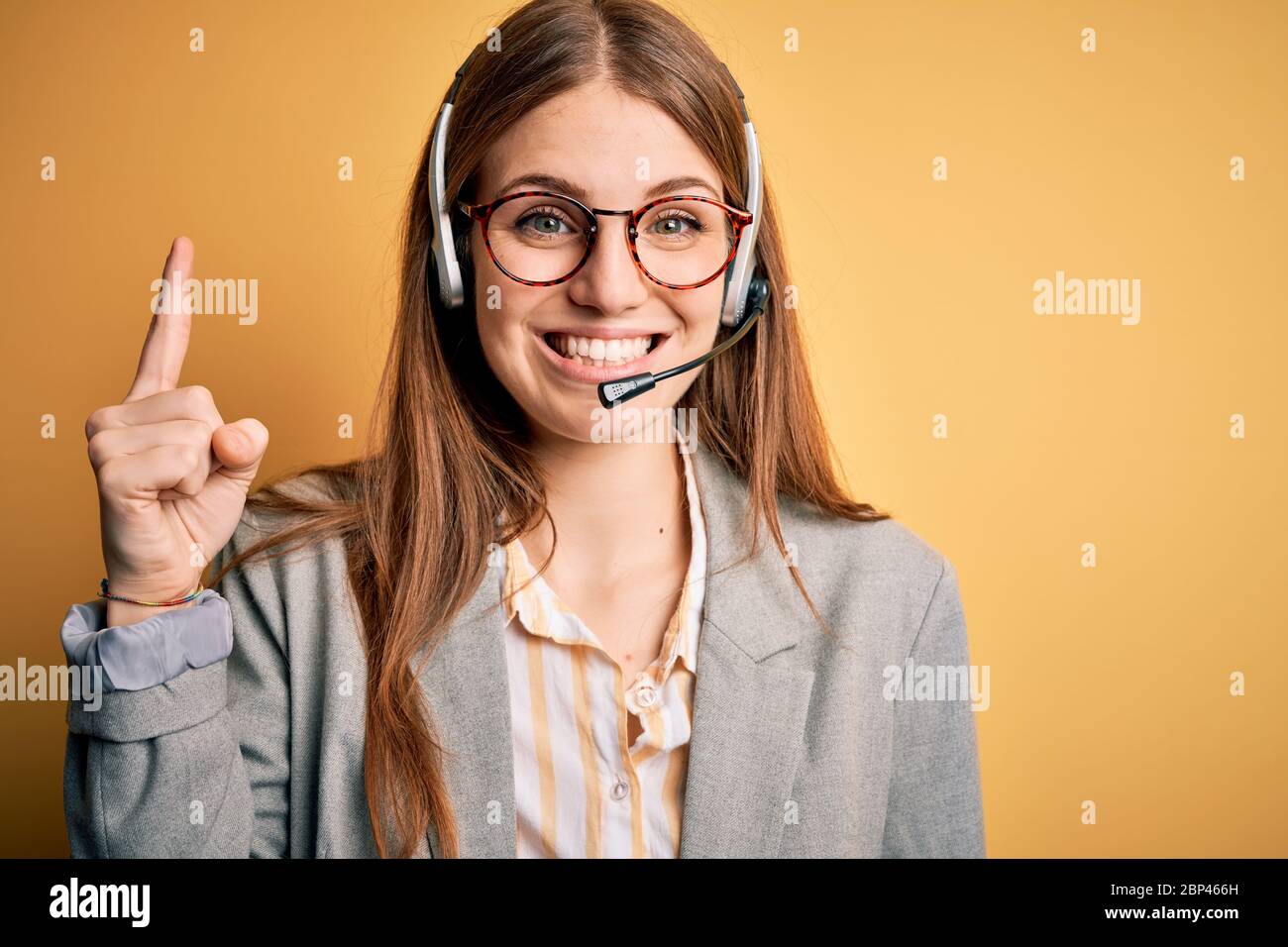 Young redhead call center agent woman overworked wearing glasses using ...