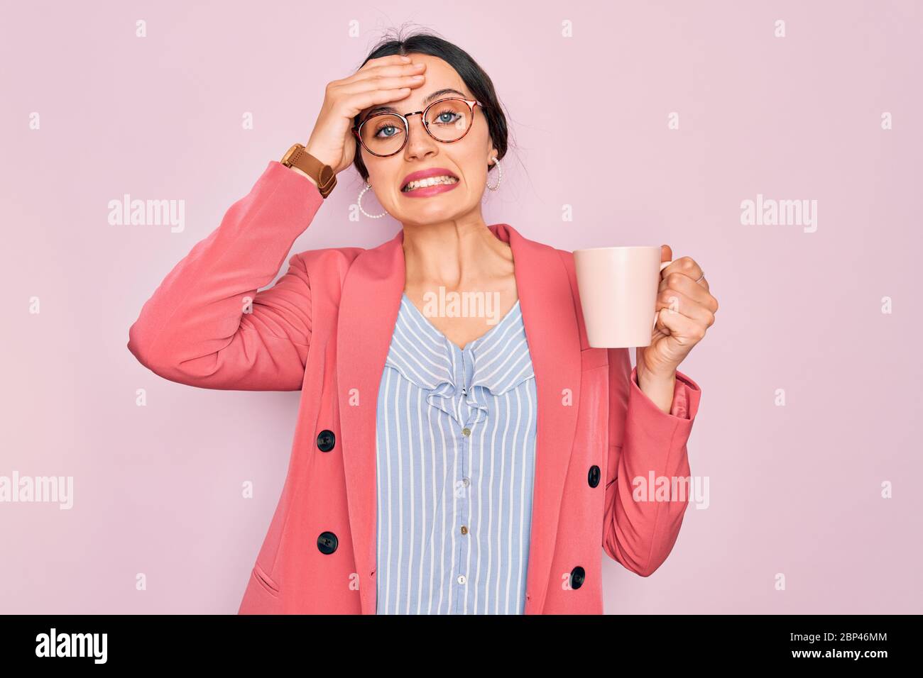 Young beautiful businesswoman with blue eyes wearing glasses drinking ...