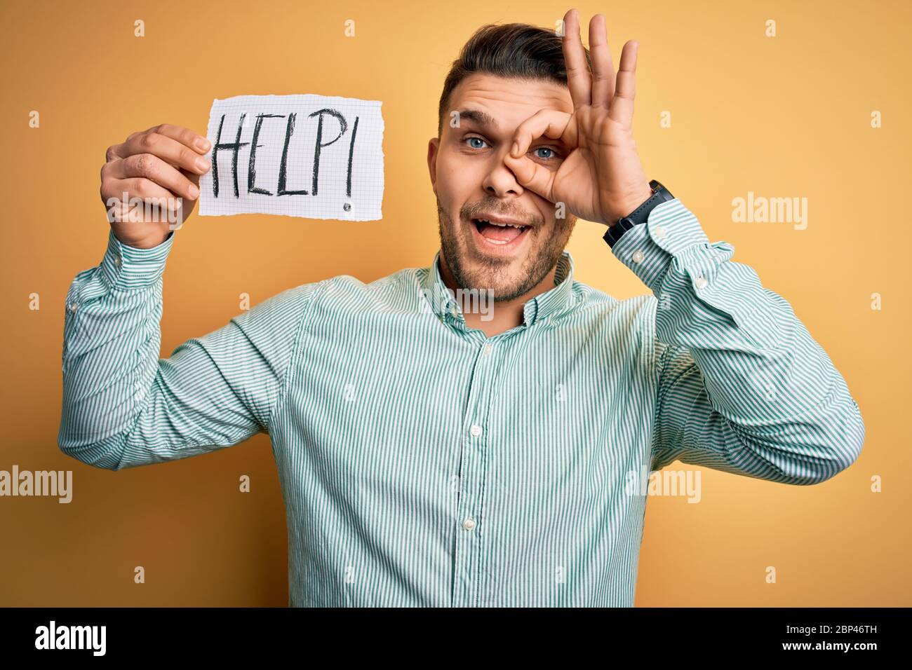 Young business man with blue eyes asking for help holding paper note ...