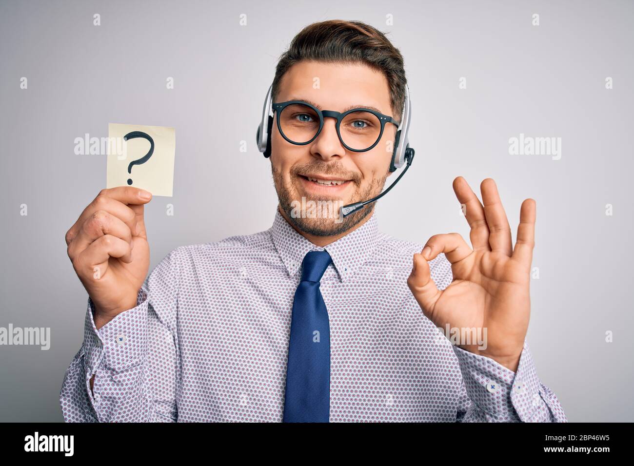 Young call center operator business man with blue eyes holding paper ...