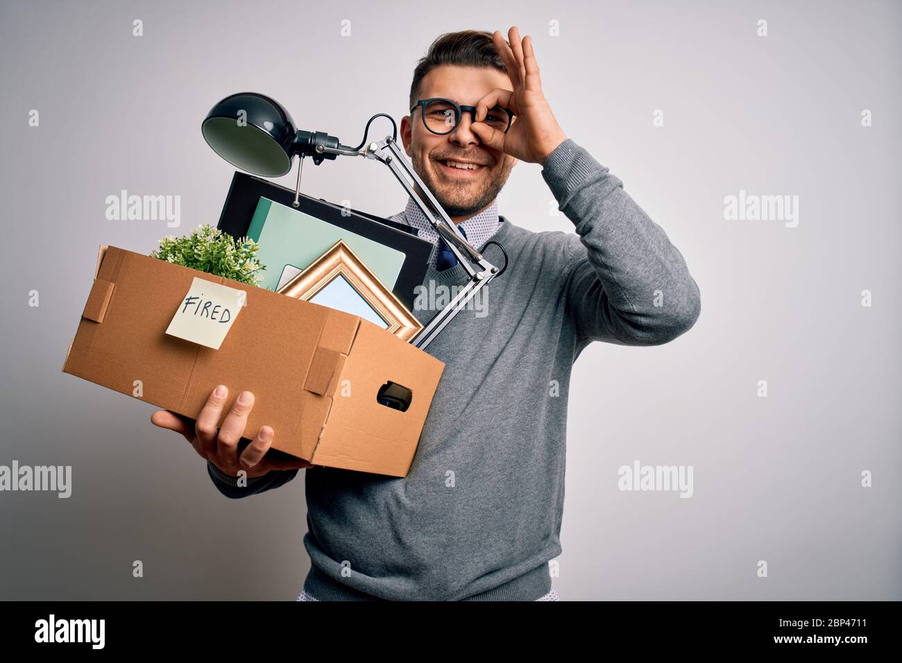 Young business man with blue eyes holding box from the office beeing ...