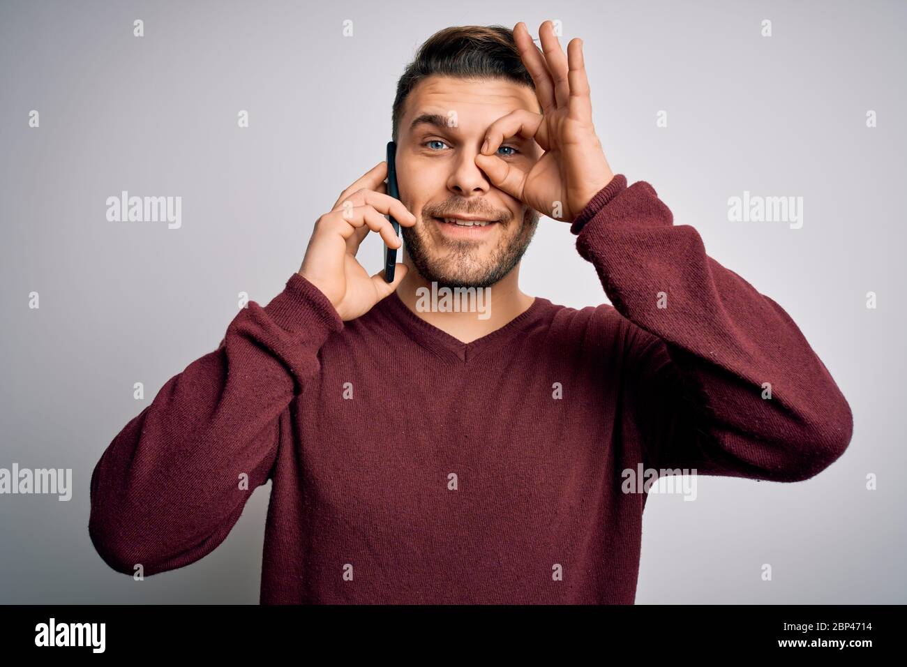 Young man with blue eyes speaking on the phone having a conversation on ...