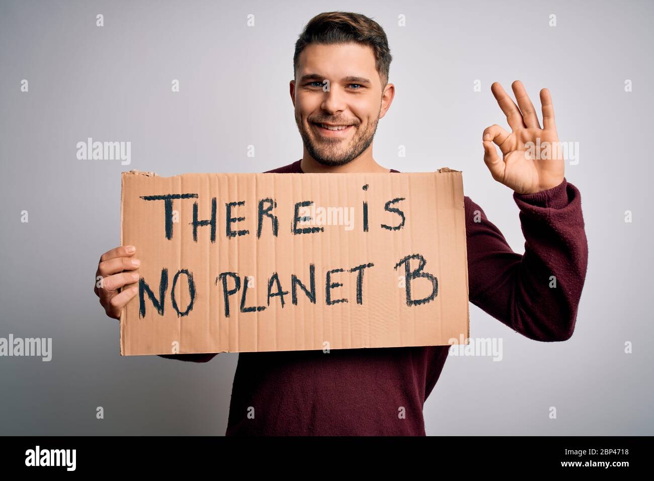 Young activist man holding protest banner for climate change and ...