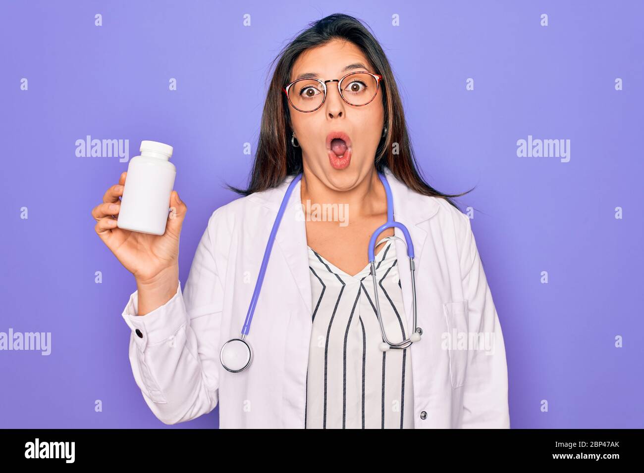 Young professional doctor woman holding pharmaceutical pills over ...