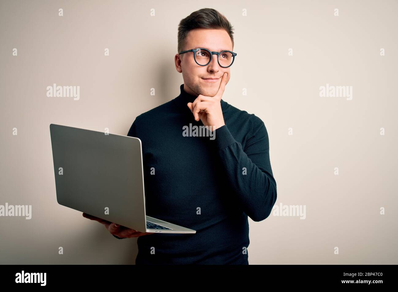 Young handsome caucasian business man wearing glasses using computer ...