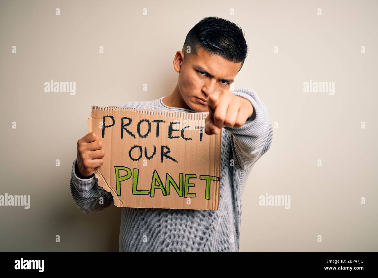 Young handsome activist latin man holding banner asking to protect our ...