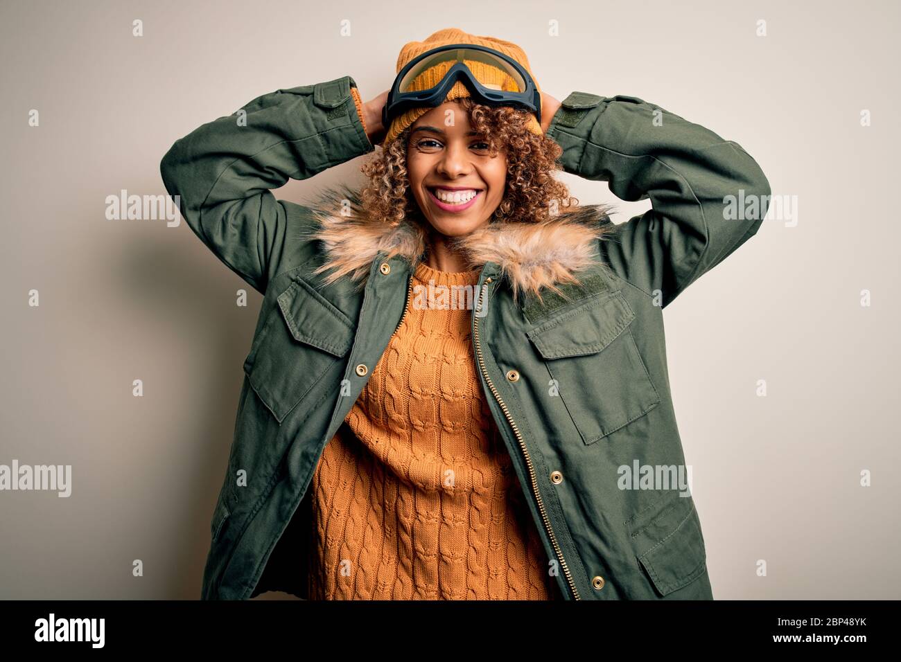 Young african american skier woman with curly hair wearing snow ...