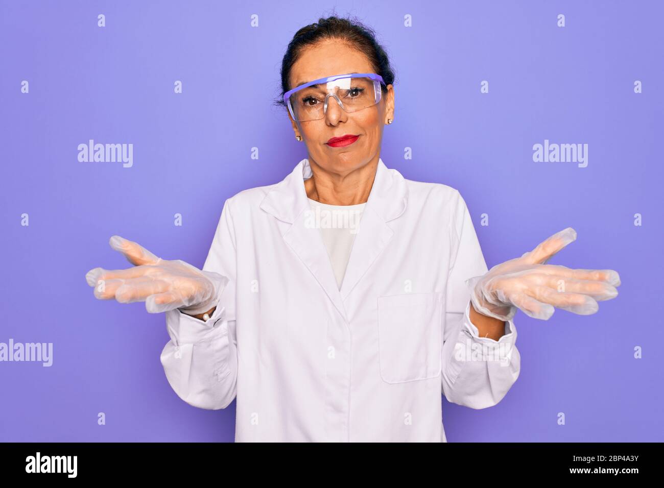 Middle age senior scientist woman wearing coat and laboratory glasses ...
