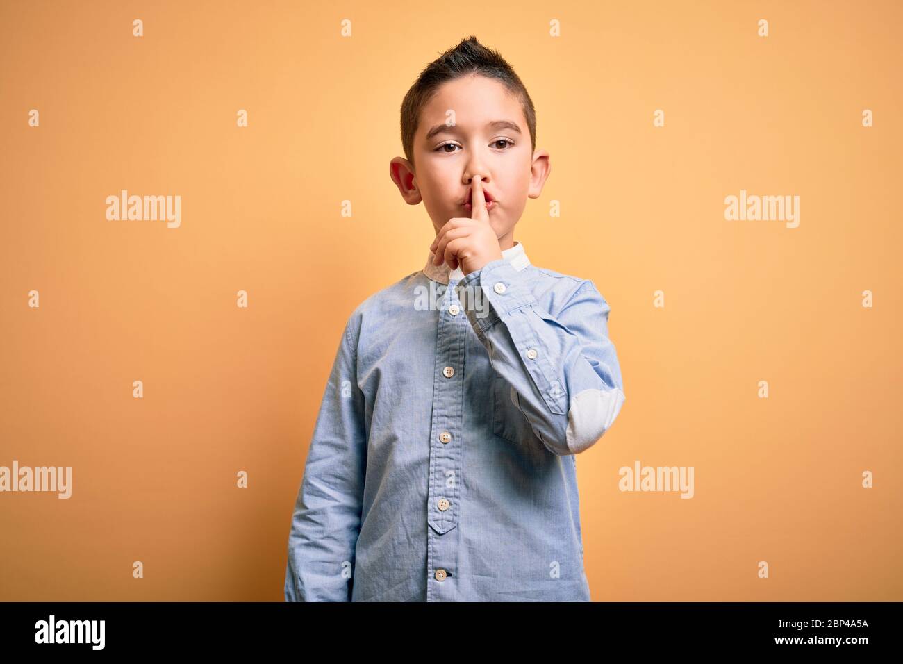 Young little boy kid wearing elegant shirt standing over yellow ...