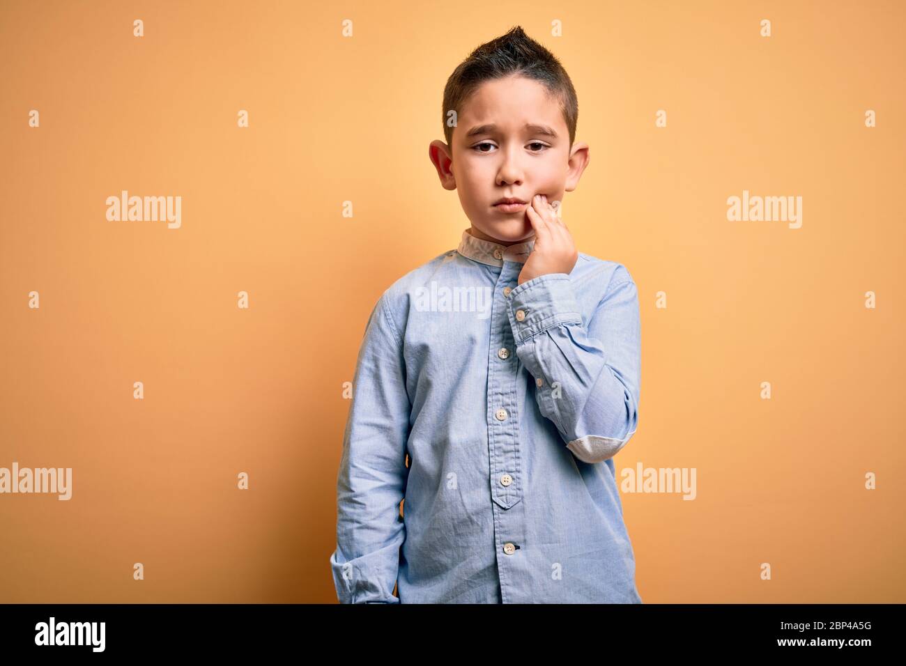 Young little boy kid wearing elegant shirt standing over yellow ...