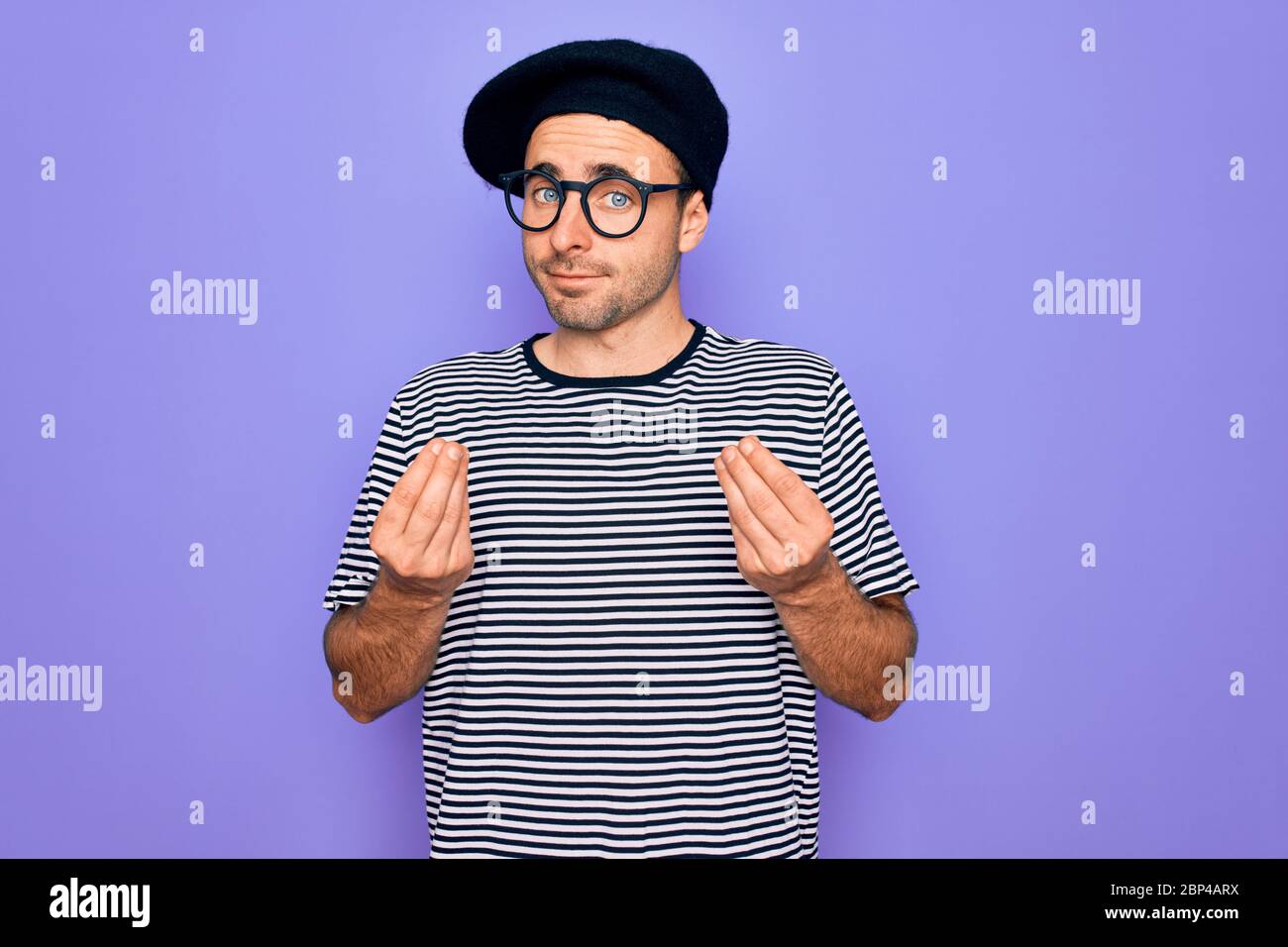 Handsome man with blue eyes wearing striped t-shirt and french beret ...