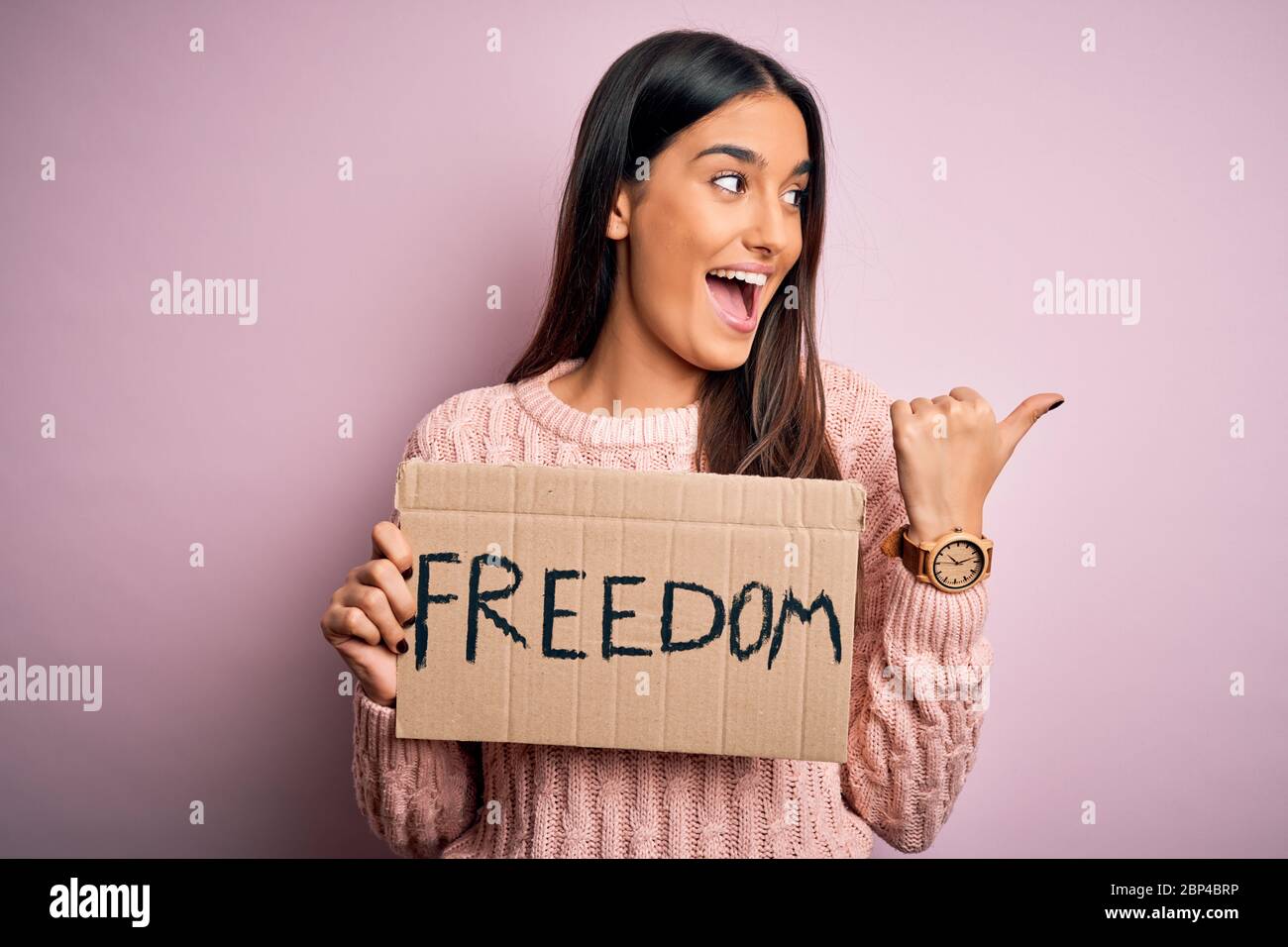 Young beautiful brunette activist woman protesting for freedom holding ...