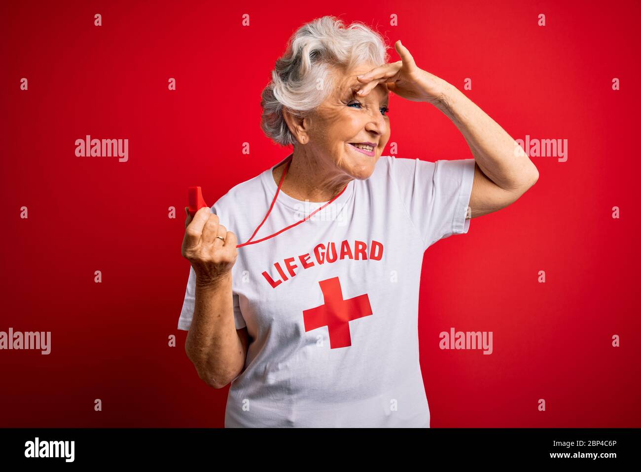 Senior beautiful grey-haired lifeguard woman wearing t-shirt with red ...