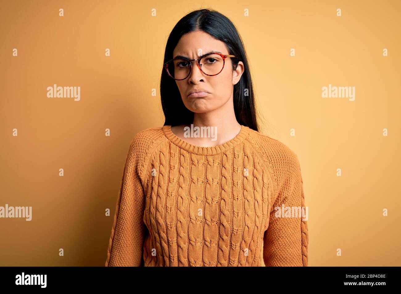 Young beautiful hispanic woman wearing glasses over yellow isolated ...