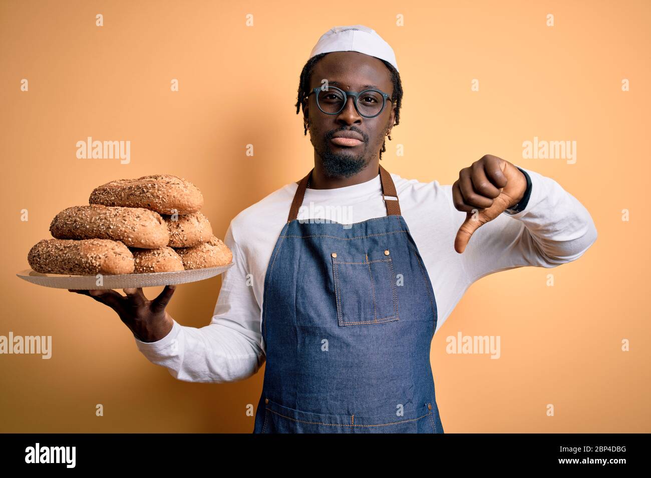 Young african american bakery man holding tray with healthy wholemeal ...