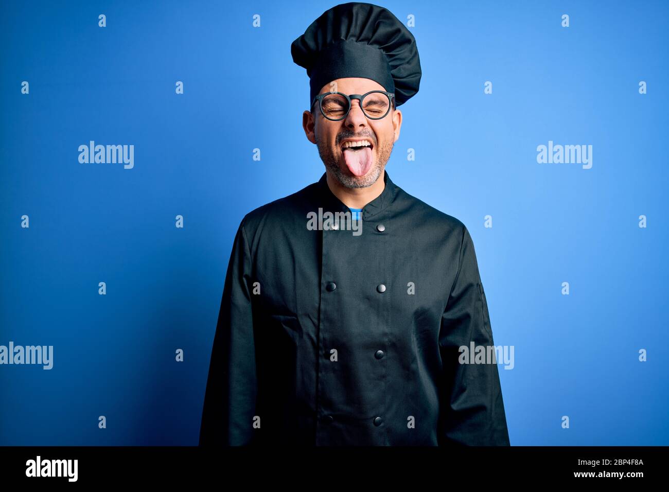 Young handsome chef man wearing cooker uniform and hat over isolated ...