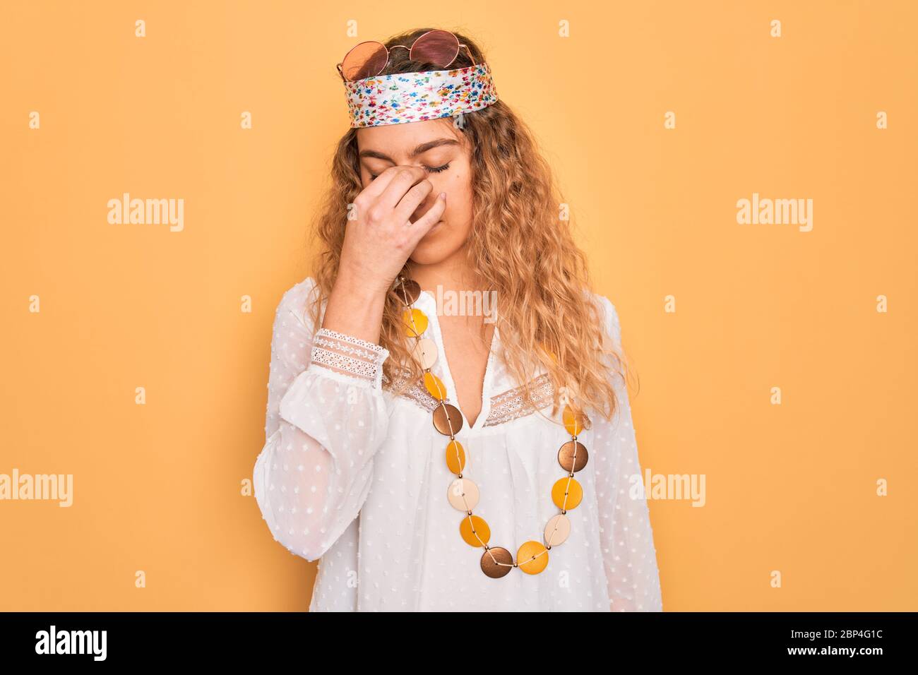 Young beautiful blonde hippie woman with blue eyes wearing sunglasses ...
