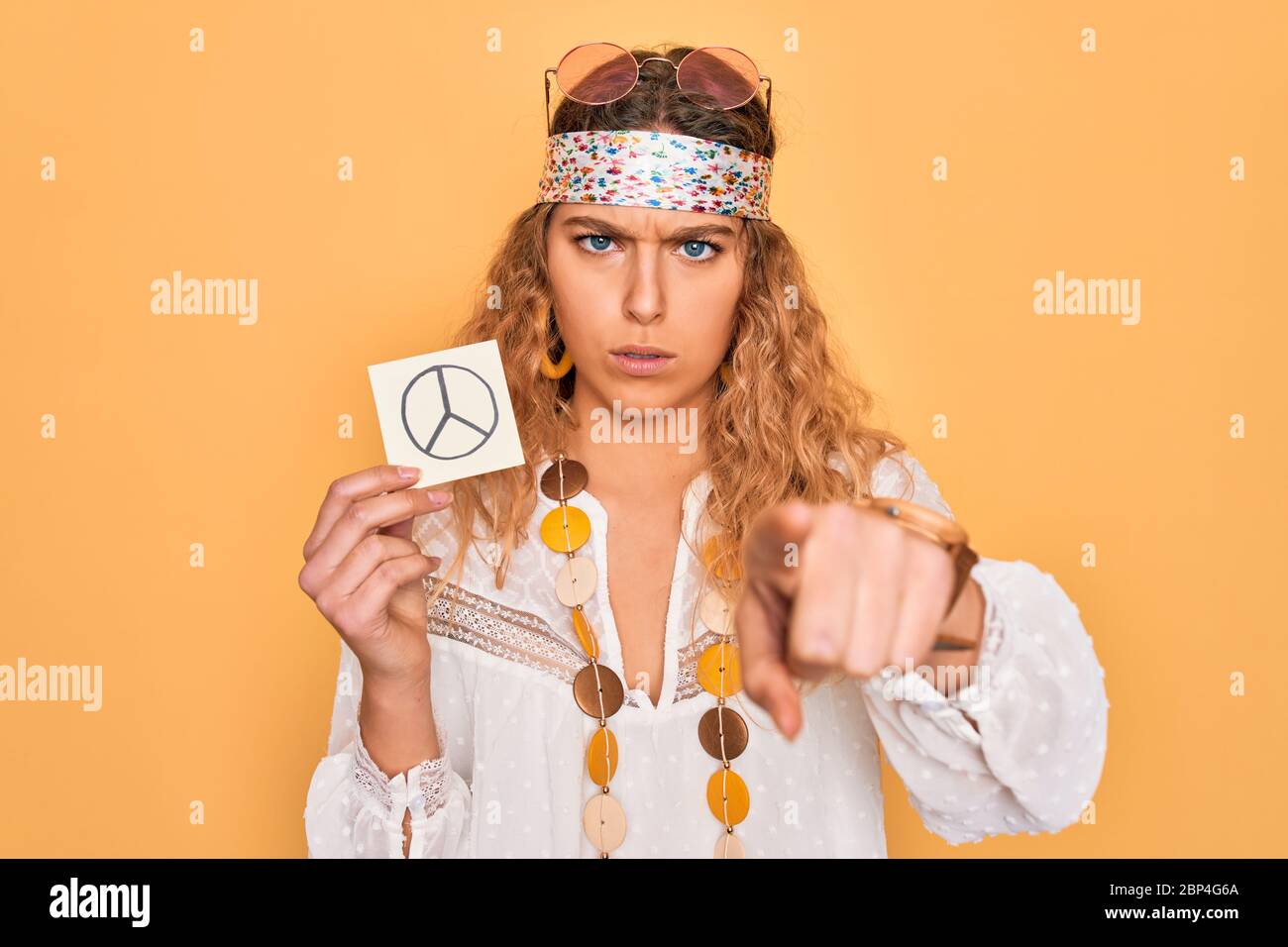 Beautiful hippie woman with blue eyes wearing sunglasses holding ...
