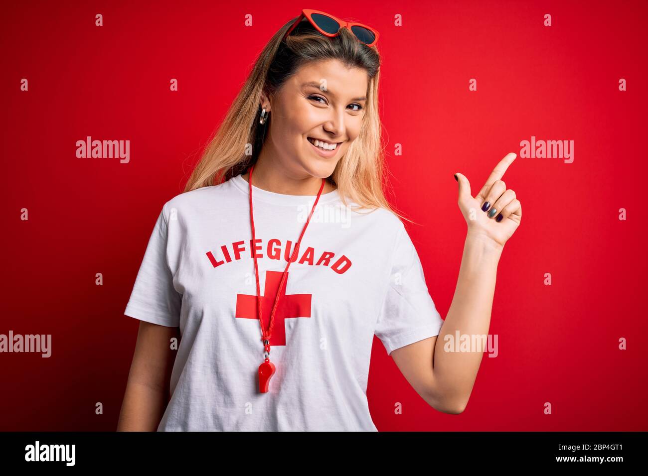 Young beautiful blonde lifeguard woman wearing t-shirt with red cross ...