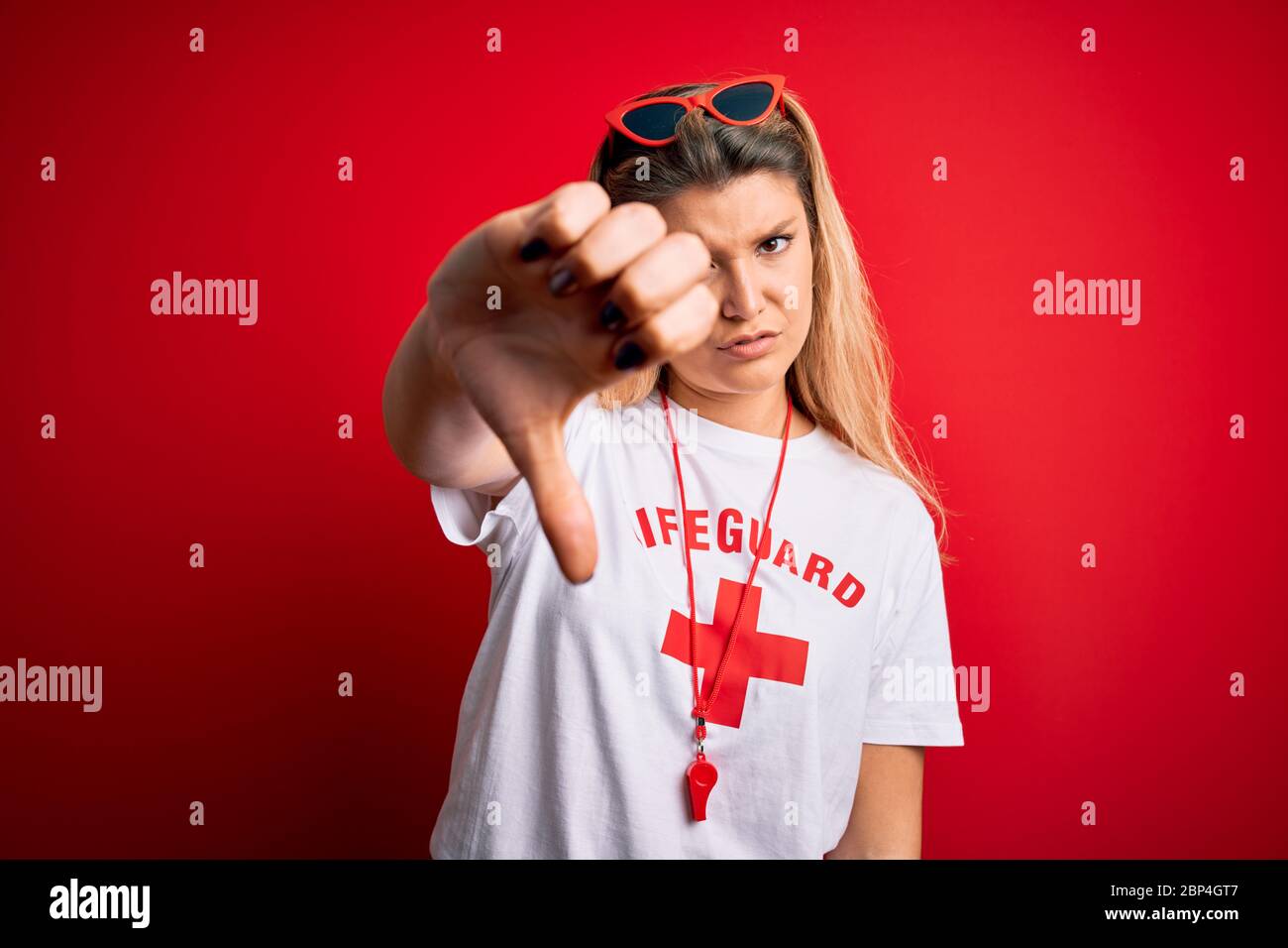 Young beautiful blonde lifeguard woman wearing t-shirt with red cross ...