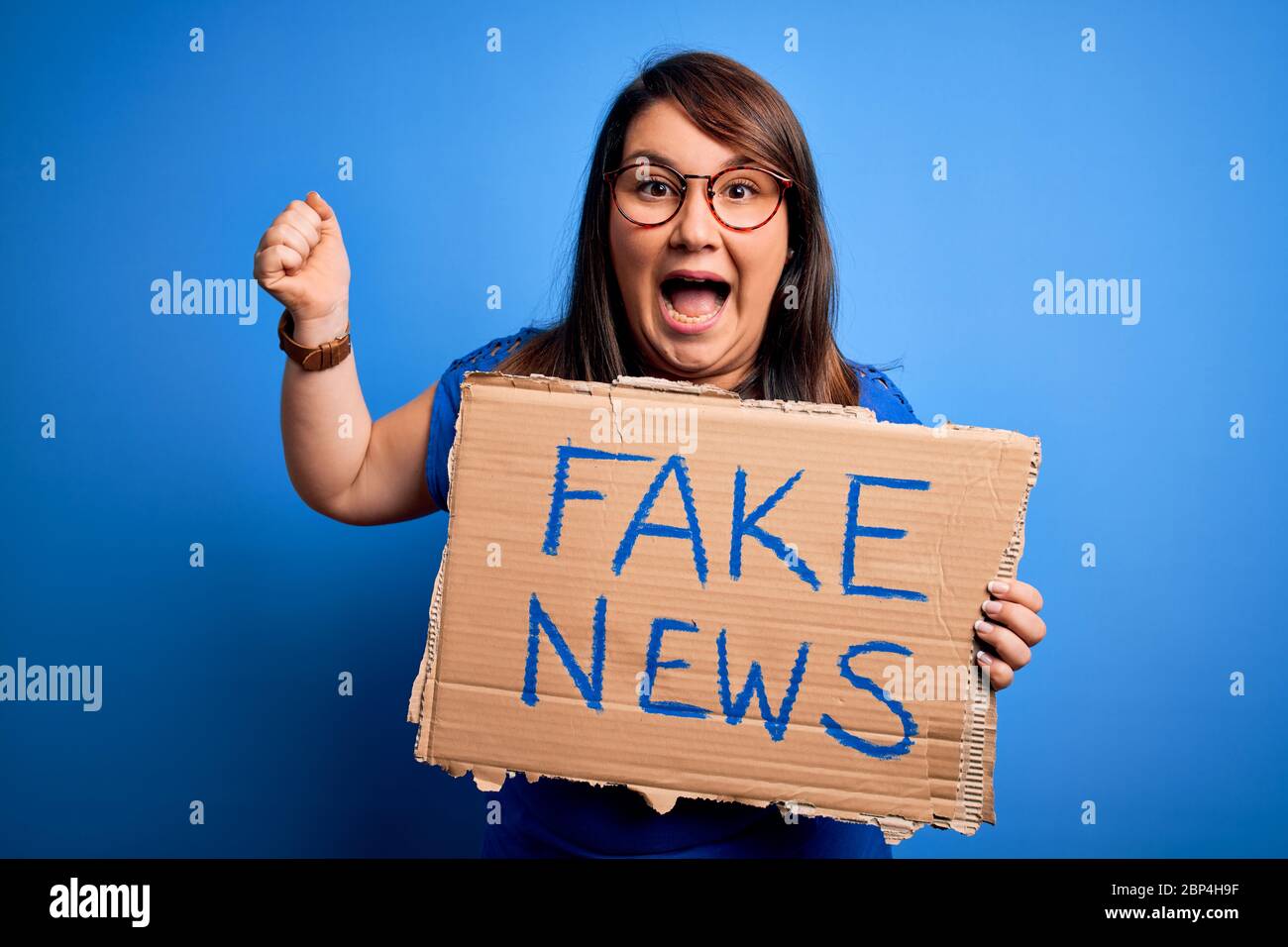 Beautiful plus size woman holding fake news banner for false journalism ...