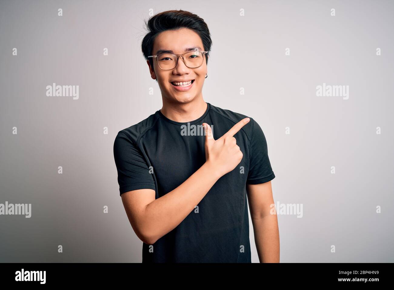 Young handsome chinese man wearing black t-shirt and glasses over white ...