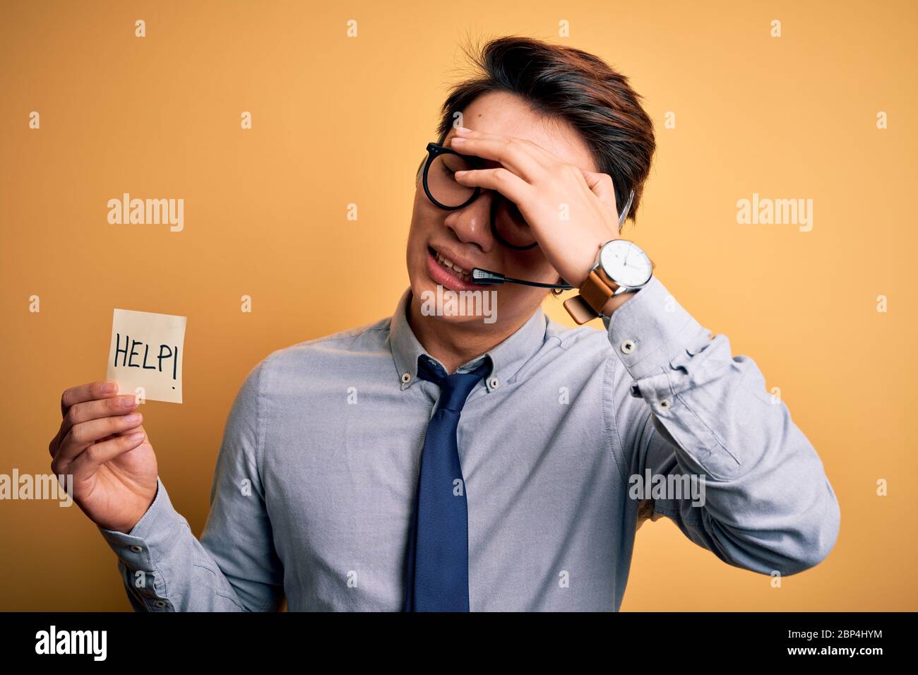Young handsome chinese call center agent man overworked using headset ...