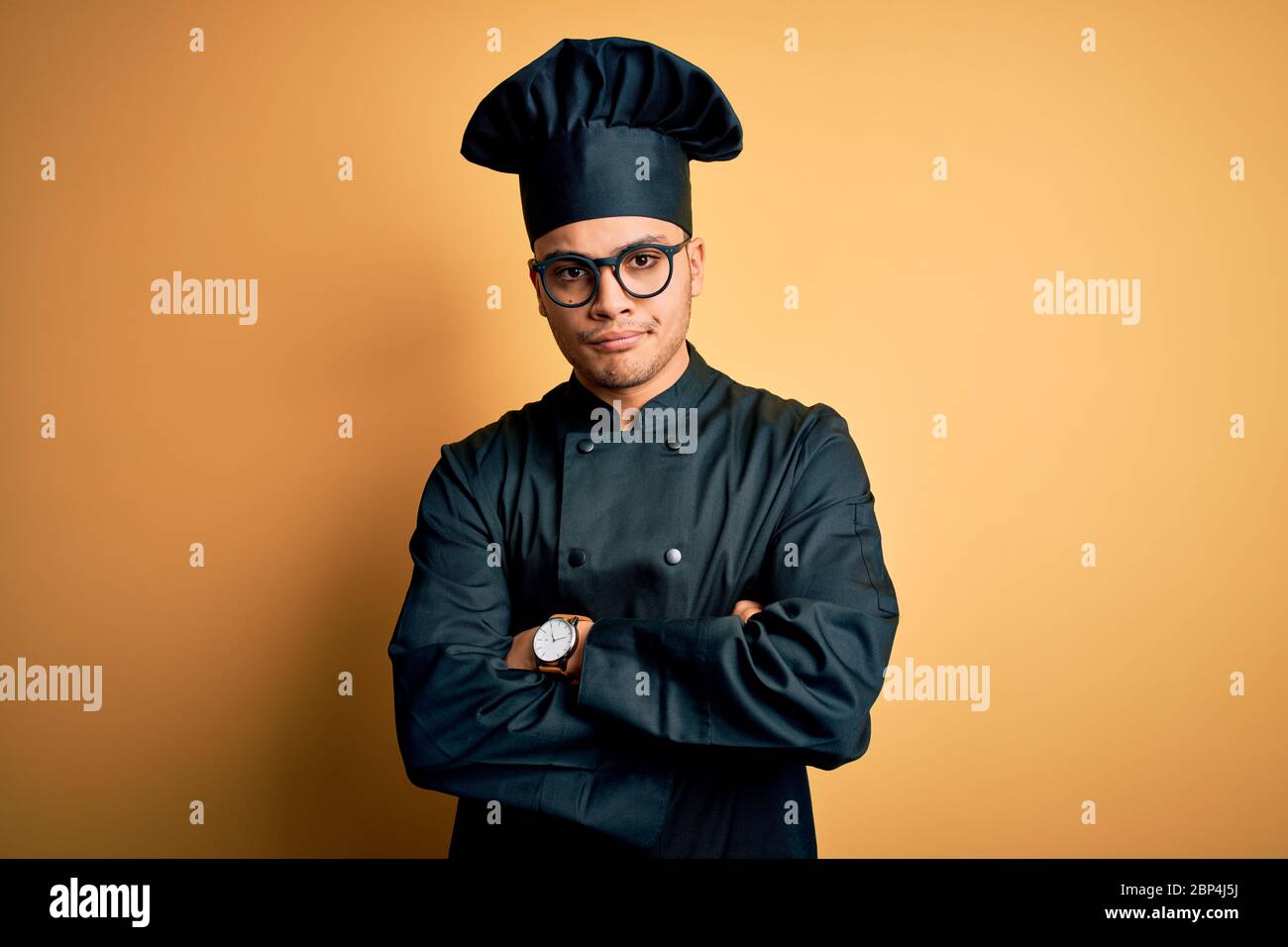 Young brazilian chef man wearing cooker uniform and hat over isolated ...