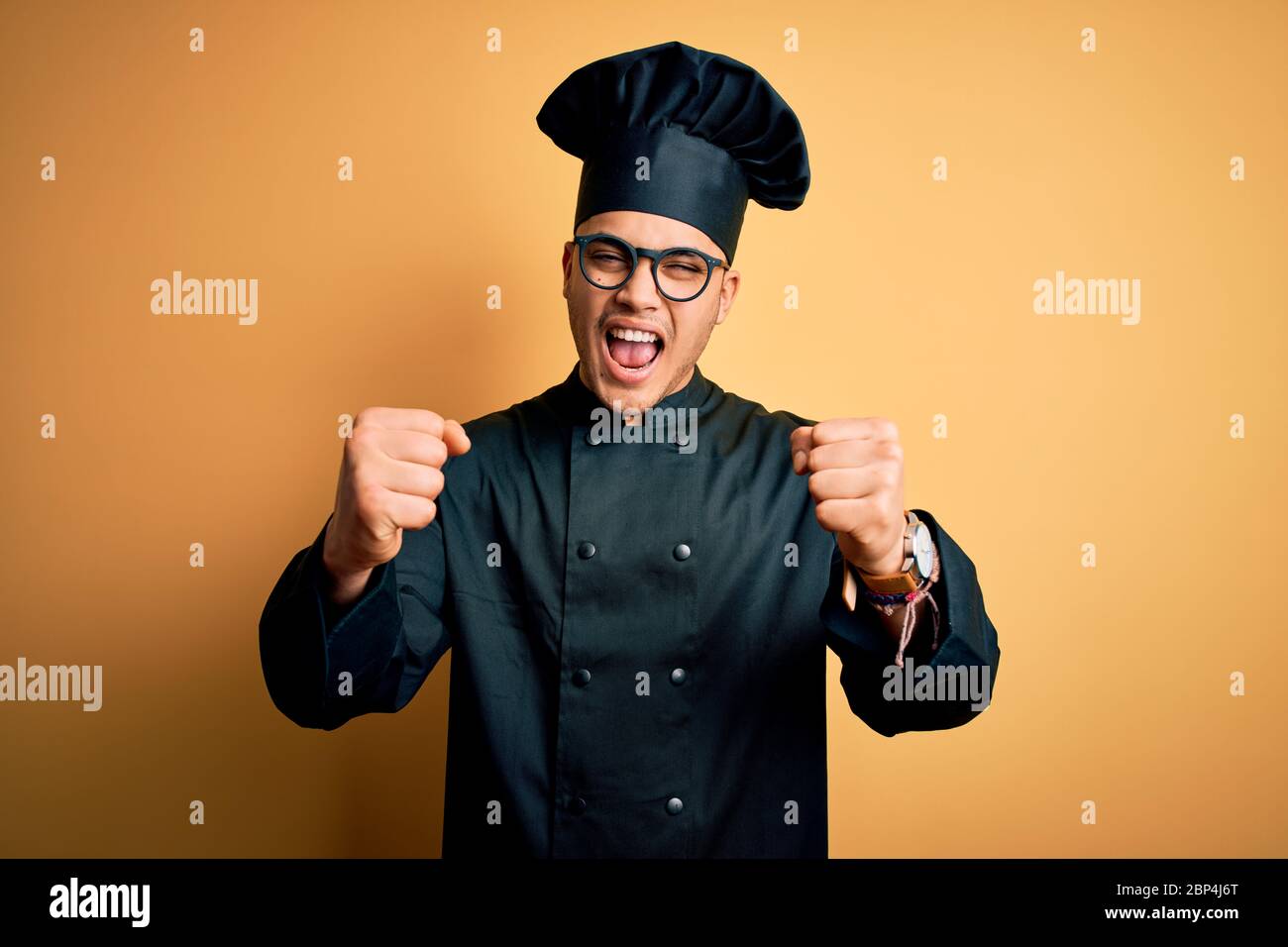 Young brazilian chef man wearing cooker uniform and hat over isolated ...