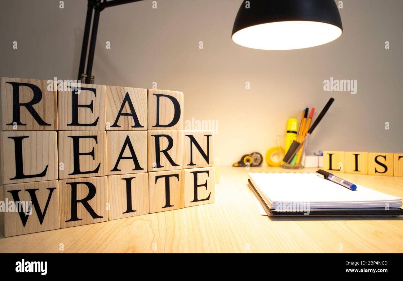 On wooden cubes, read learn write, writes texts. There are desktop lamp ...