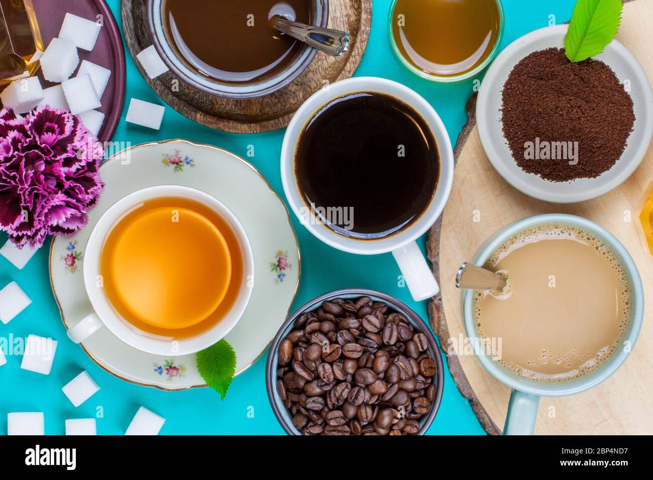 Collection of tea and coffee cups, with sugar cubes and coffee beans ...