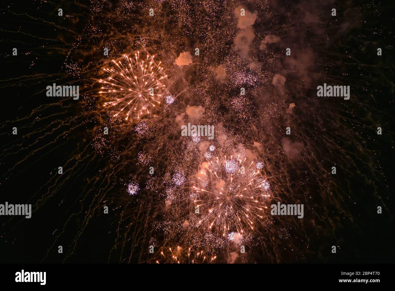 Red and orange fireworks with smoke over the black sky. Low key ...