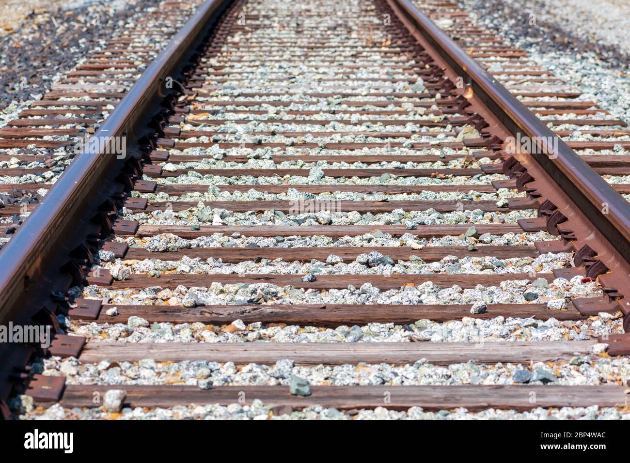 Railway track with wooden sleepers and ballast stone gravel. Selective ...