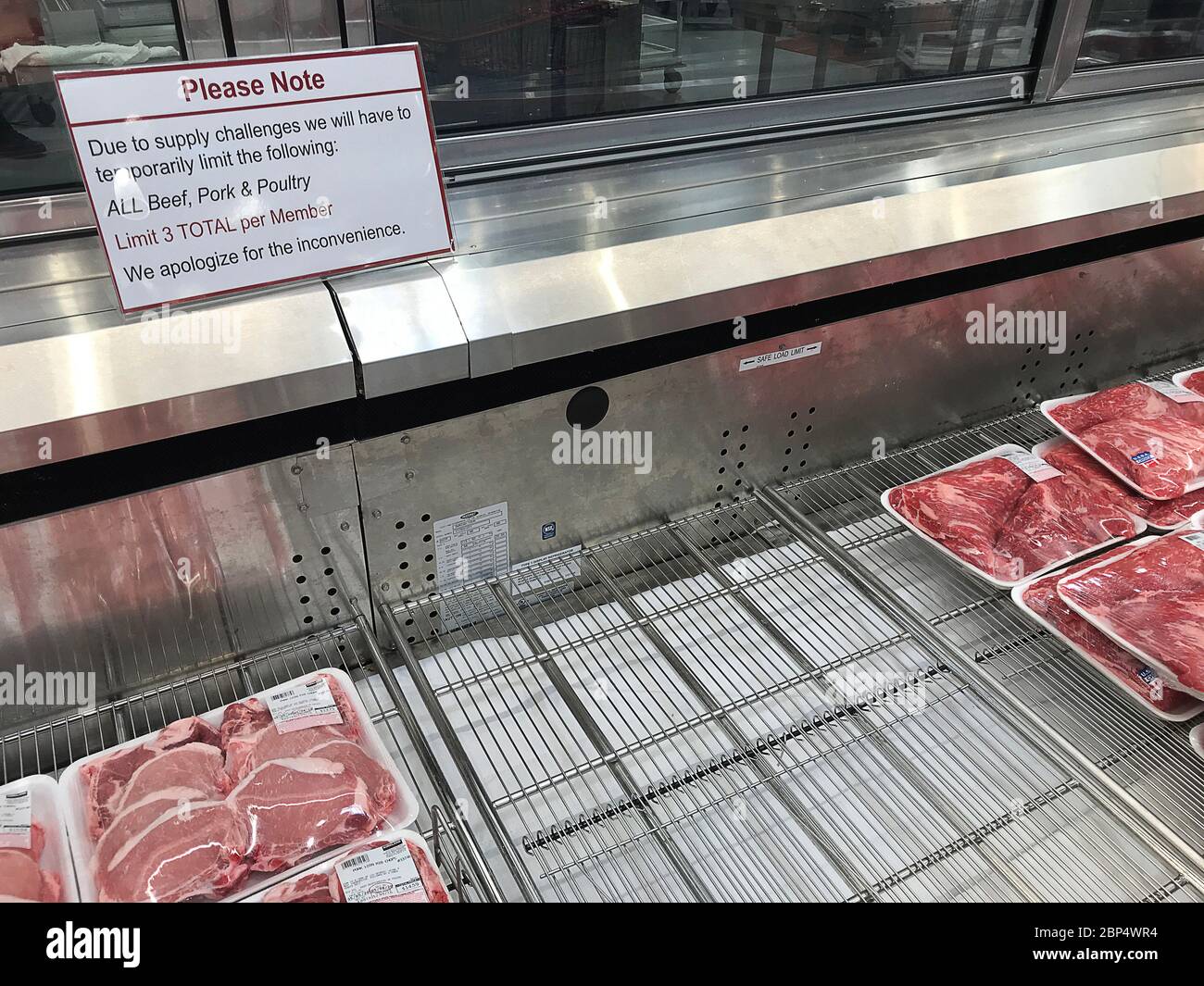 Empty shelf in the meat department of grocery store with sign informing ...