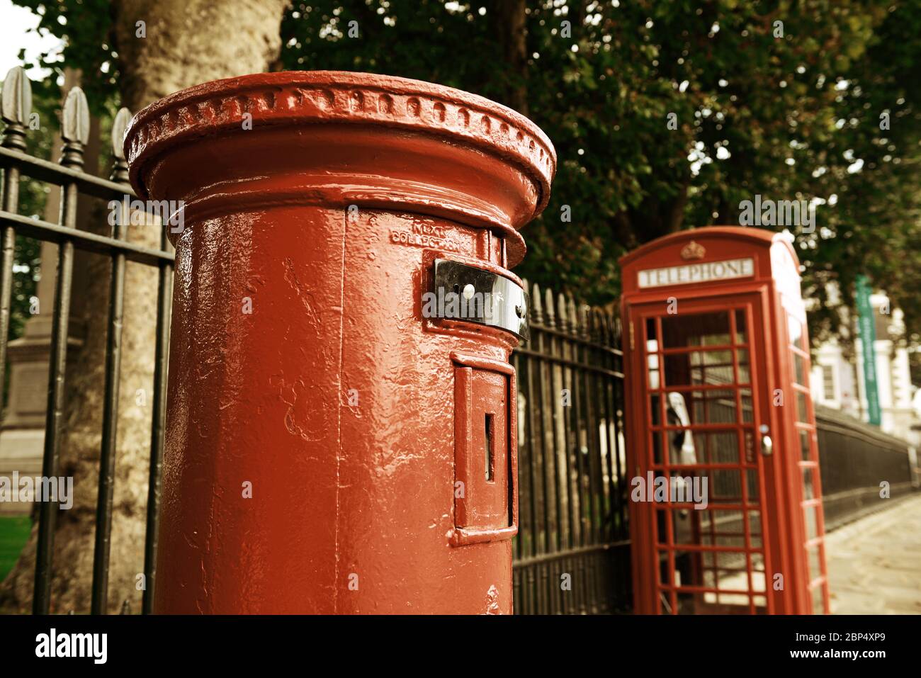 Red telephone and post box in street with historical architecture in ...