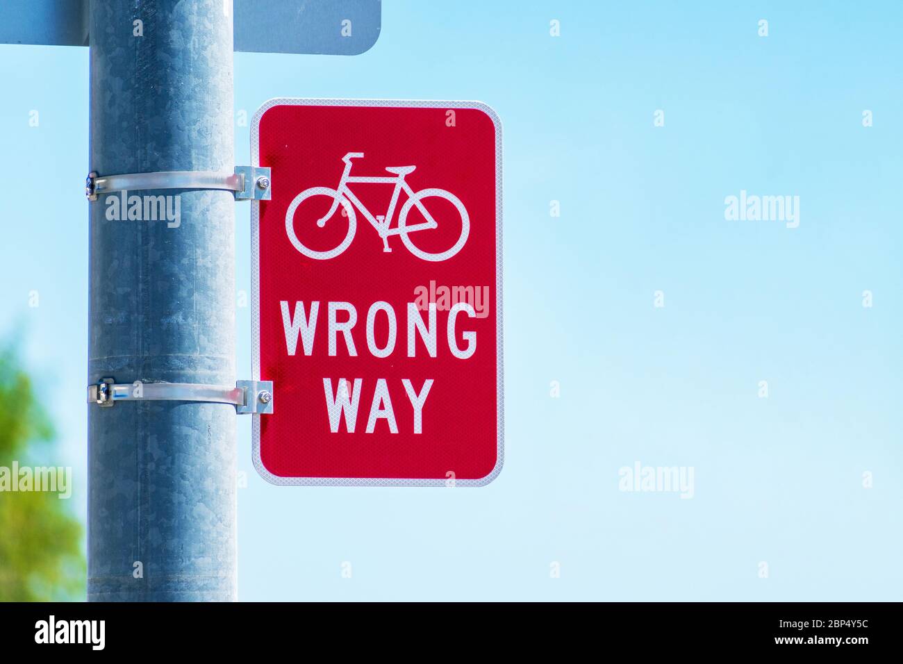 Red bicycle wrong way sign on street pole placed facing wrong-way ...