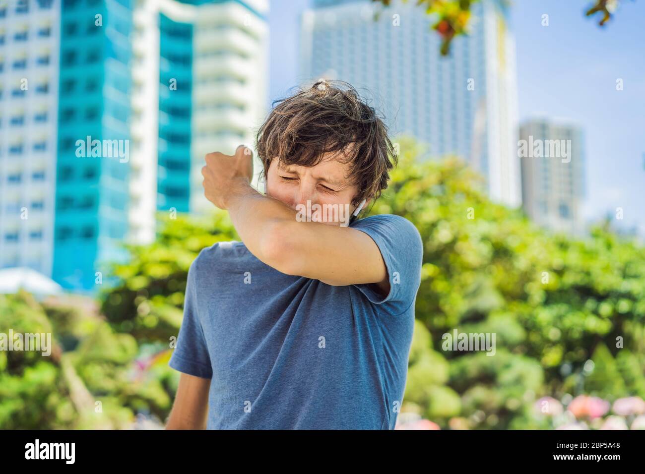 How to sneeze correctly. Man sneezes on the elbow. Concept of the ...