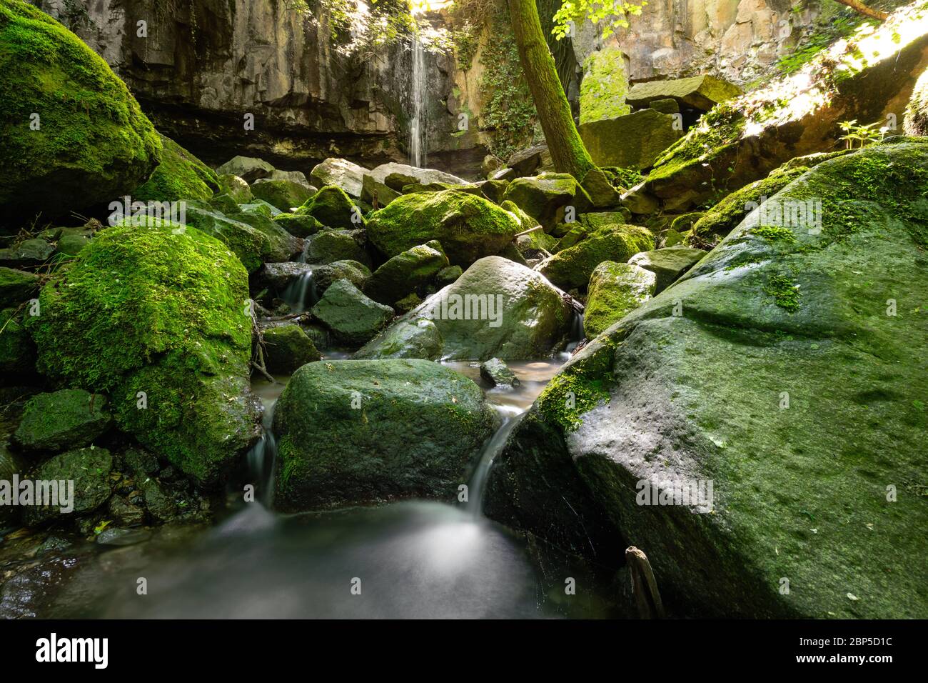 Wide angle view of a small mountain waterfall, with a creek running ...