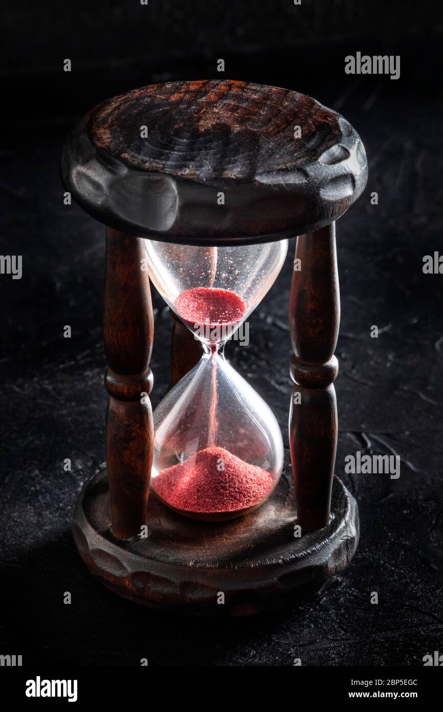 Time is running out concept. An hourglass with sand falling through, on ...