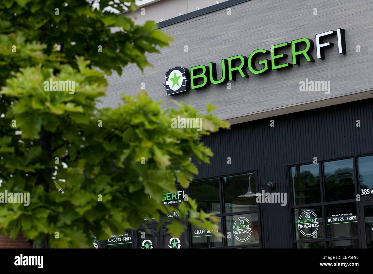 A logo sign outside of a BurgerFi restaurant location in ...