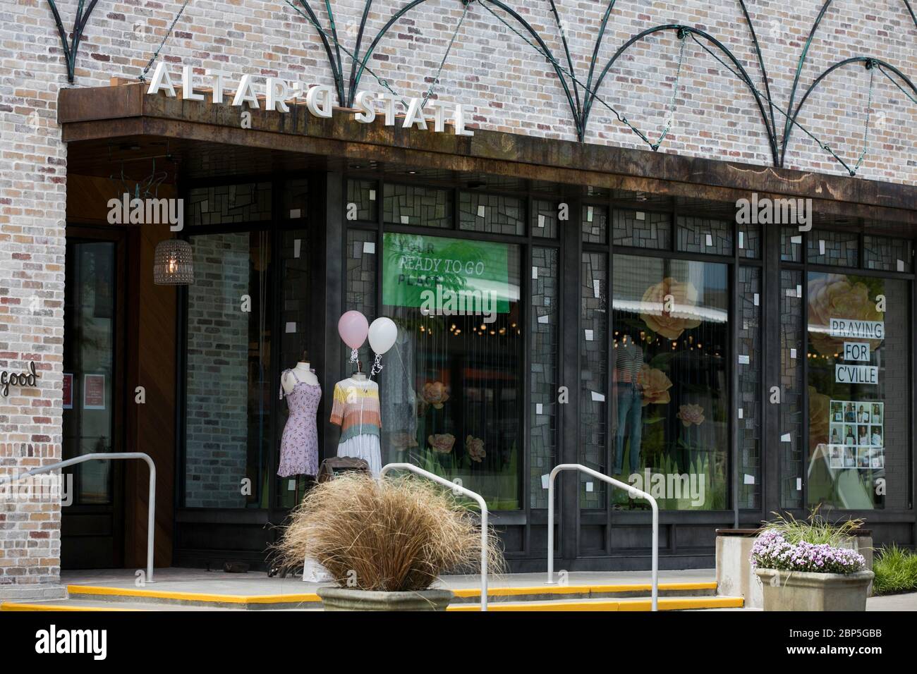A logo sign outside of a Altar'd State retail store location in ...