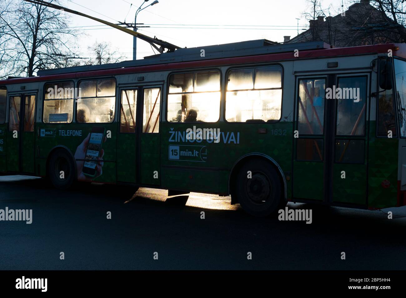 A metro, commuter bus, electric tram with the sun shining through it on ...