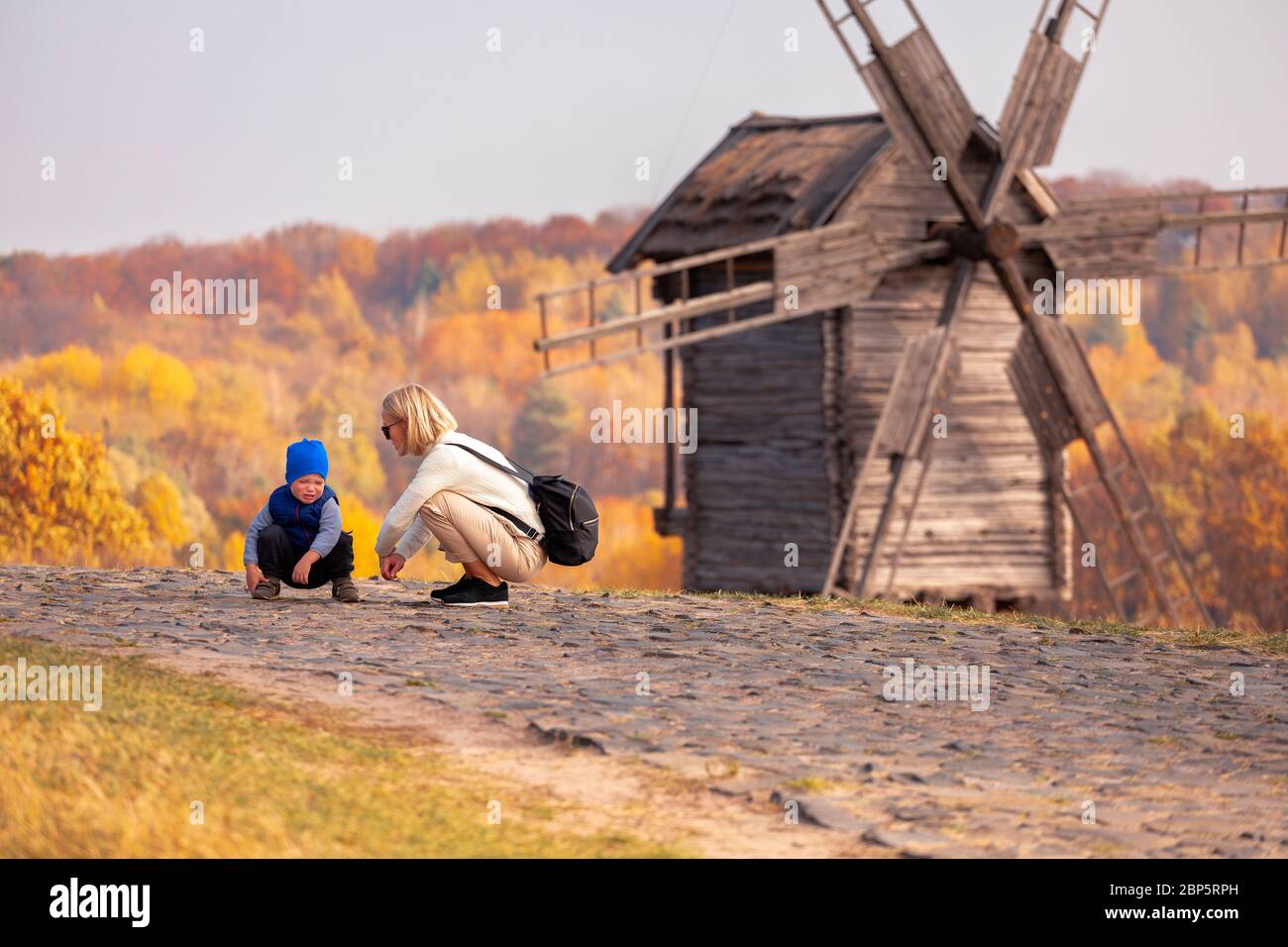 Mother calms her crying toddler boy while walking in the park Stock ...