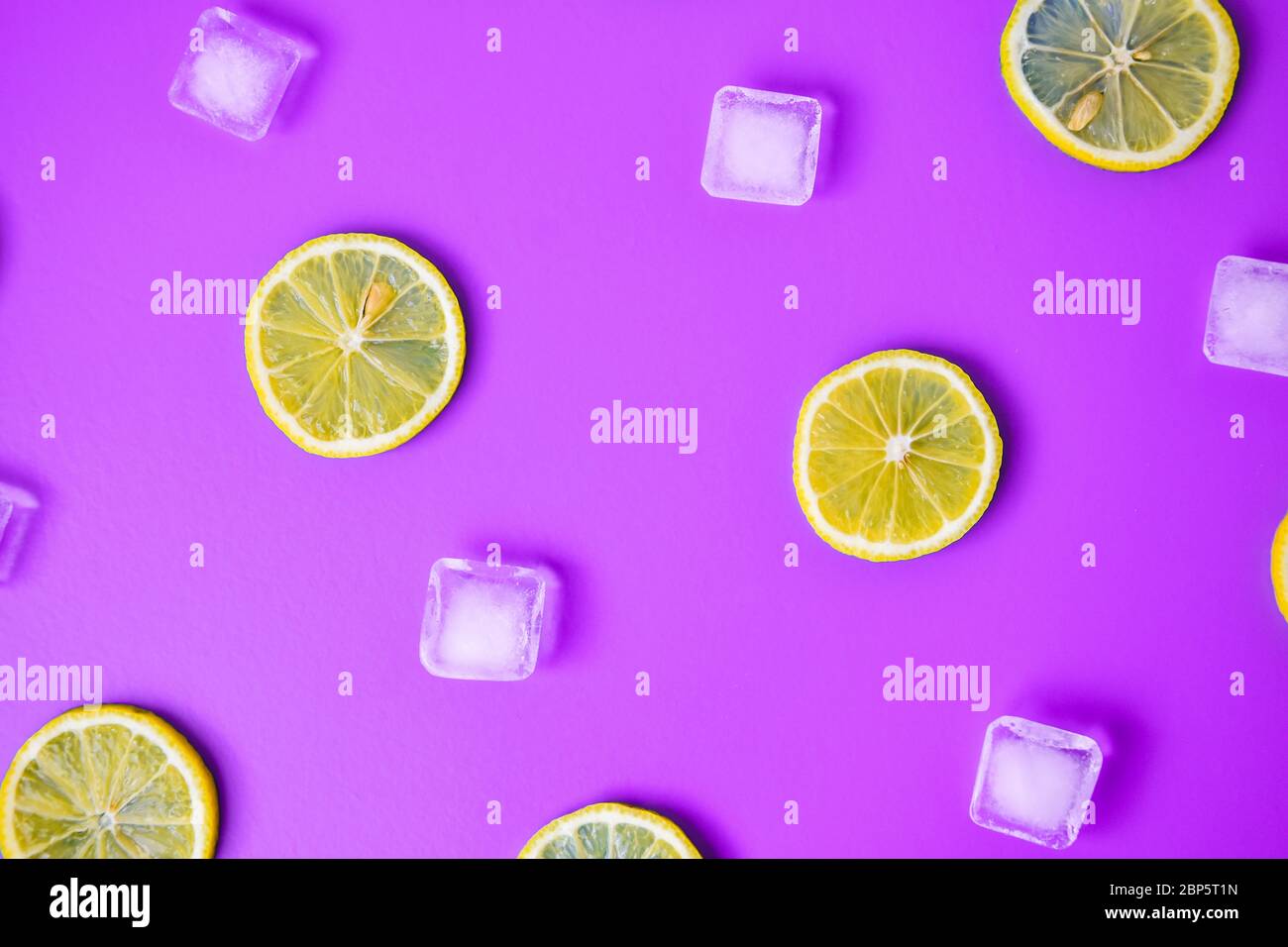 Lemonade layout with juicy lemon slices, ice cubes on purple background ...