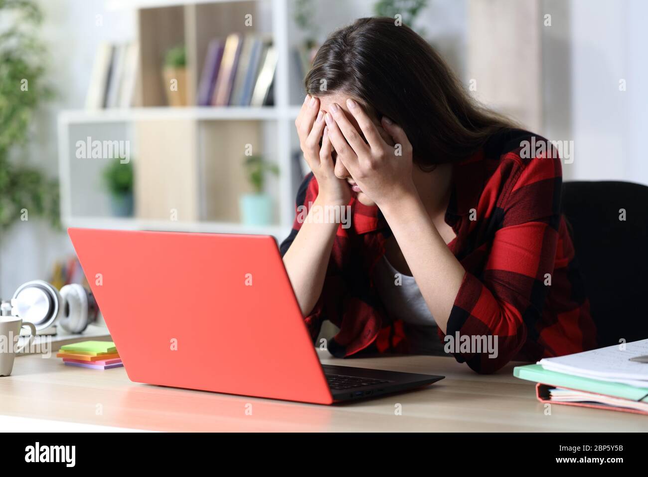 Sad student woman with red laptop complaining covering her face sitting ...