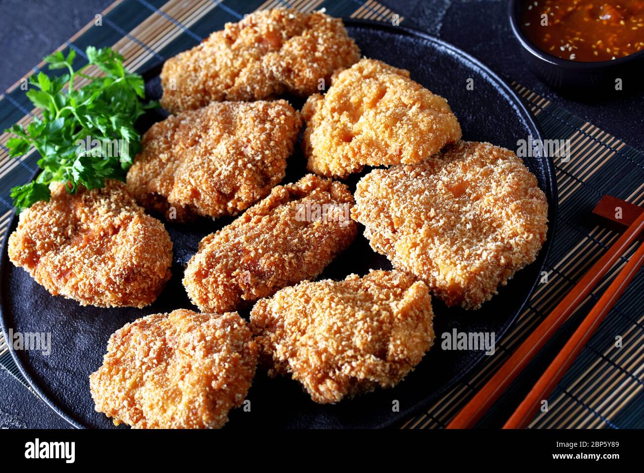close-up of HireKatsu, Japanese pork cutlets on a black plate with ...