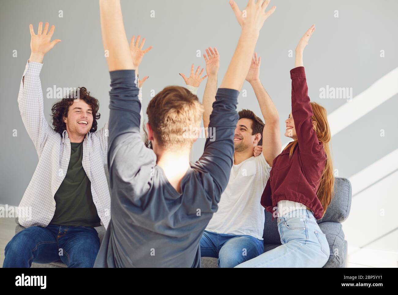Happy people cheerfully connected their hands in a room with a window ...